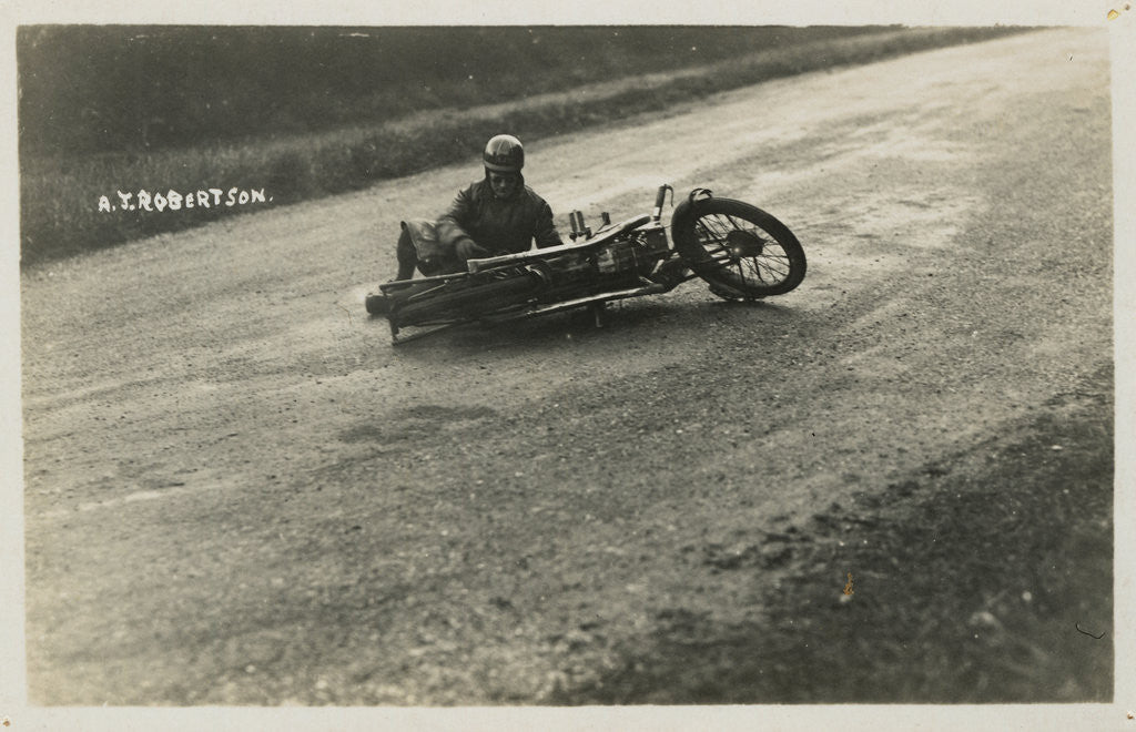 Rider A.J. Robertson on the ground, with his machine laid down on the ...