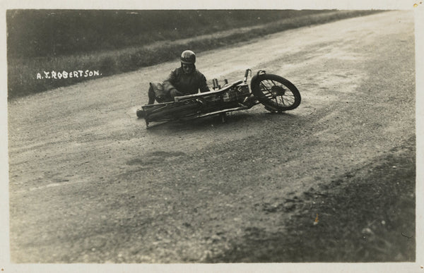 Rider A.J. Robertson on the ground, with his machine laid down on the ...